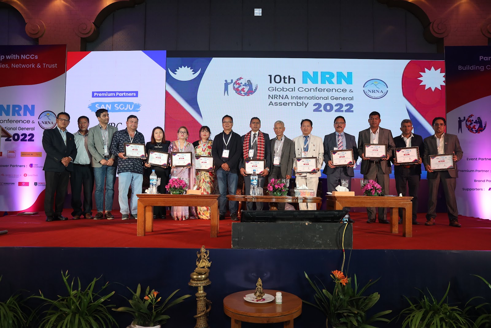 People standing on stage with certificates